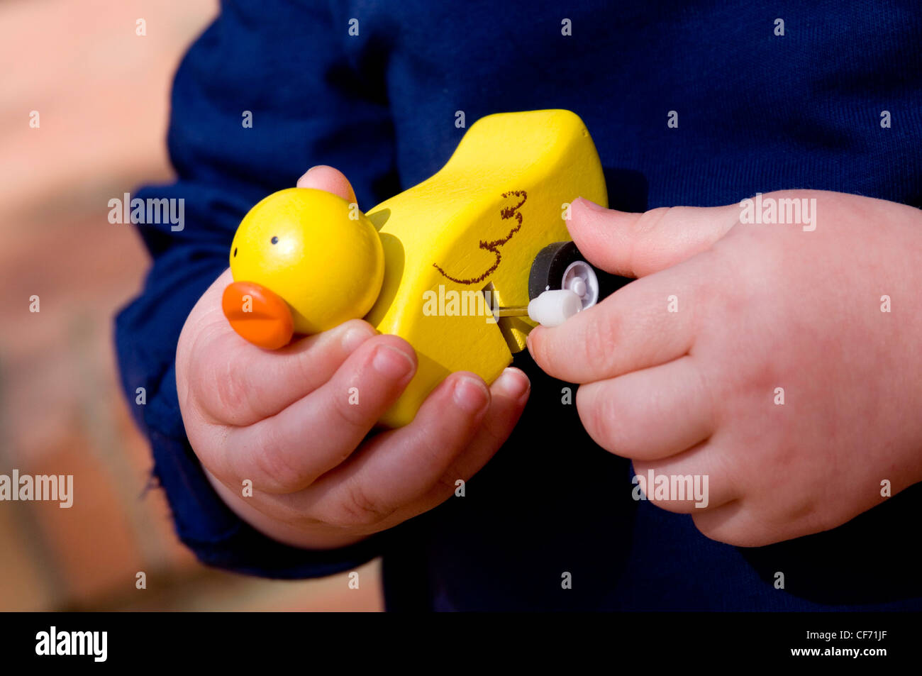 Male child playing with wind up duck toy Stock Photo - Alamy