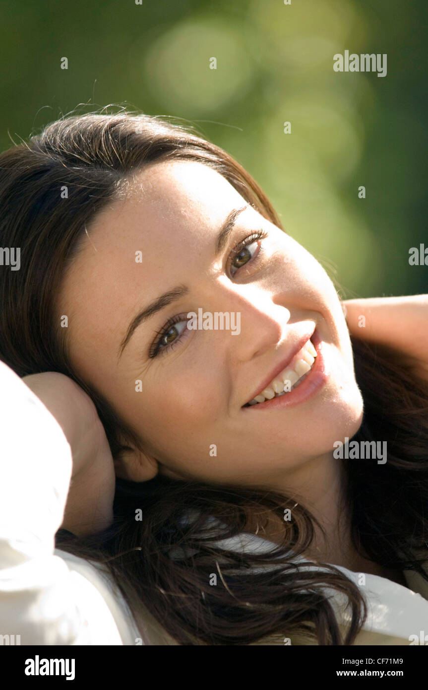 Female wearing cream jacket hands behind neck, head tipped back Stock ...