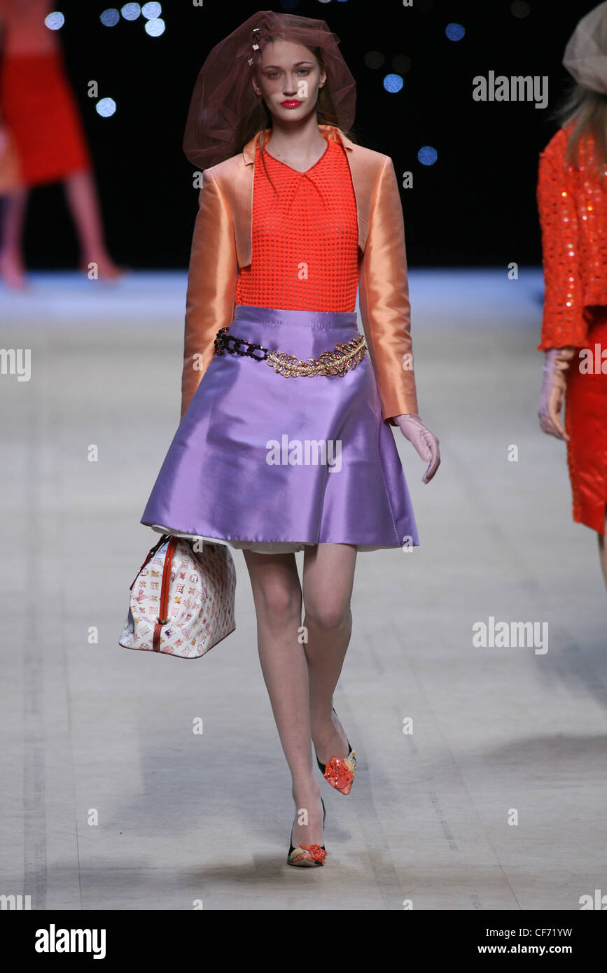 Orange cropped taffeta jacket over red top and purple skirt, look ...
