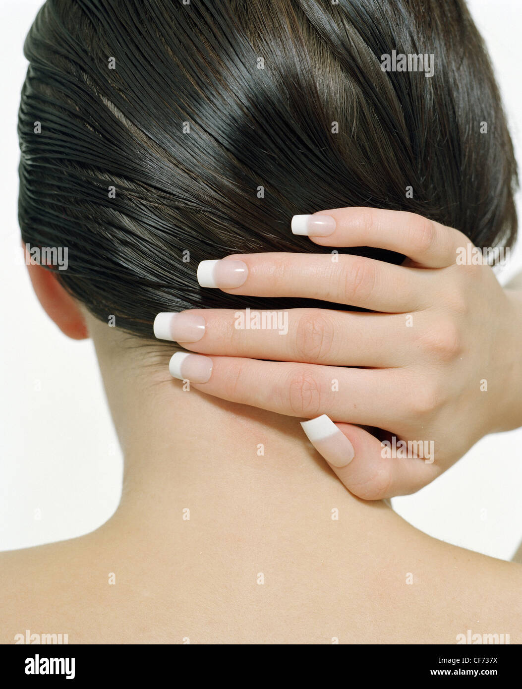 Female with long French manicured nails with hand on back of head Stock ...