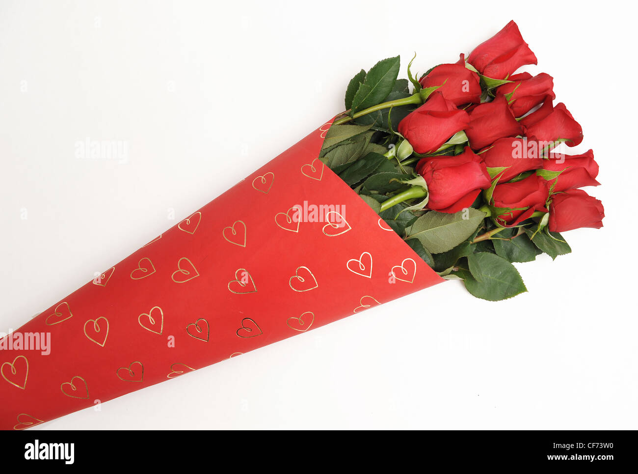A still life image of a bunch of red roses wrapped in red paper with ...