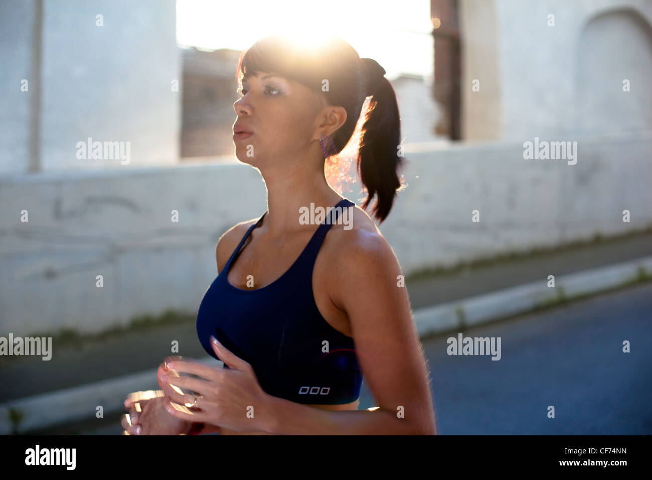 Early morning run - Female Running with sun behind Stock Photo - Alamy