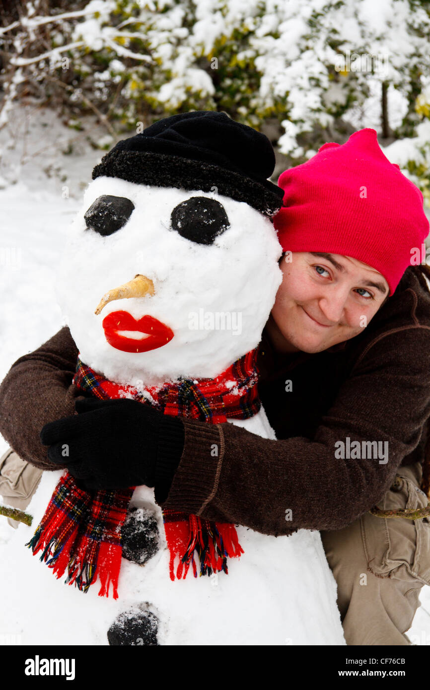 Young man hugging a snowman Stock Photo - Alamy