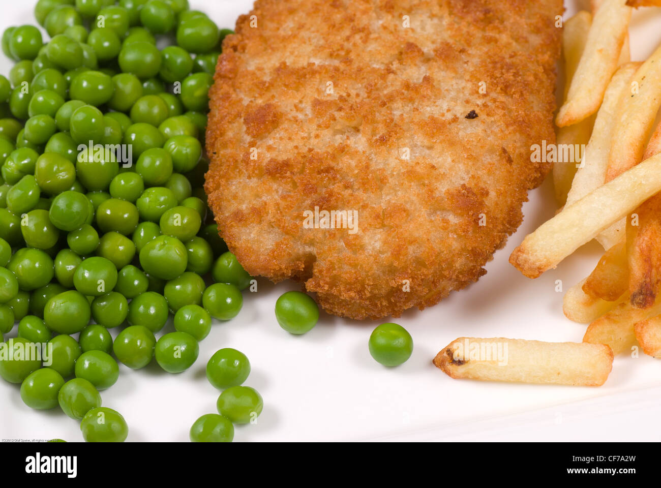 Battered hake served with fries and peas Stock Photo - Alamy
