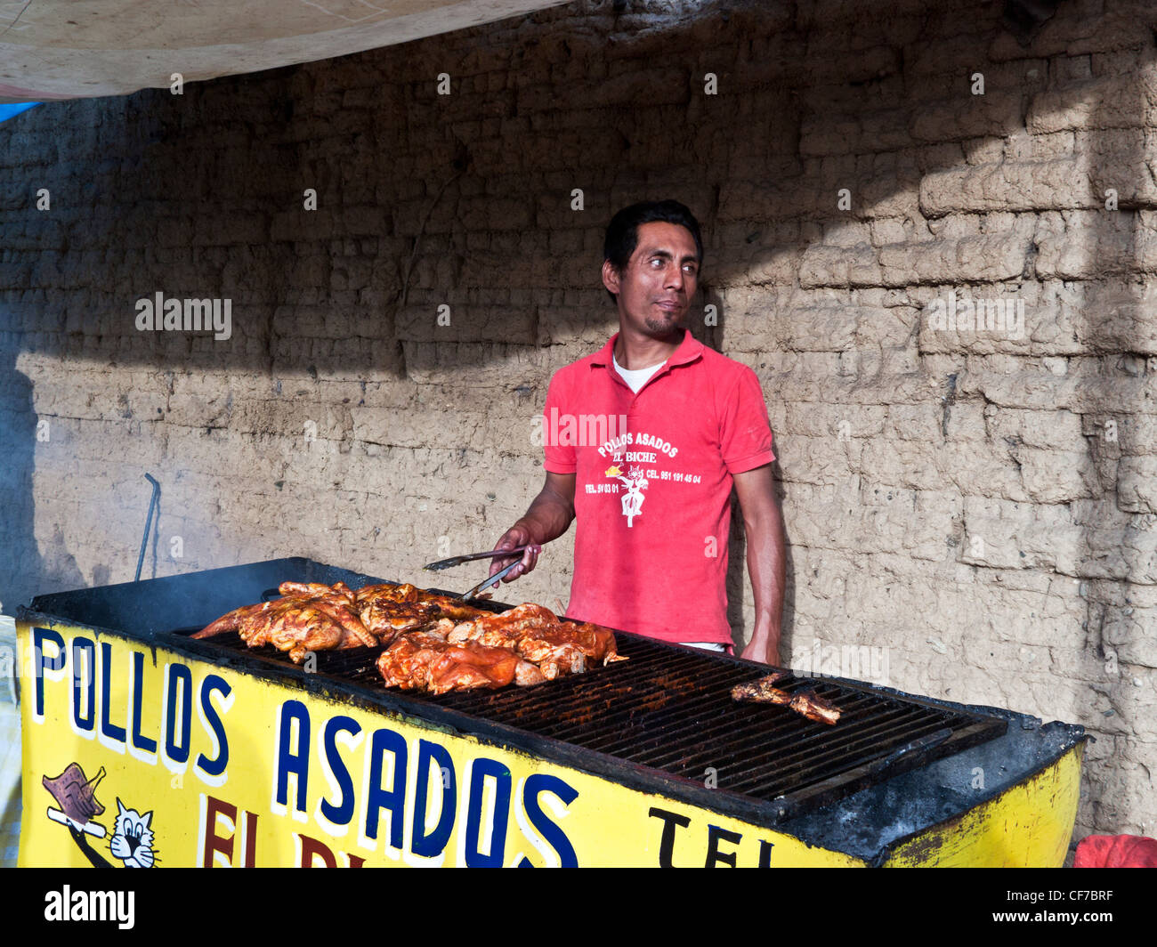 man with goatee tending marinated grilled chickens street food for sale ...