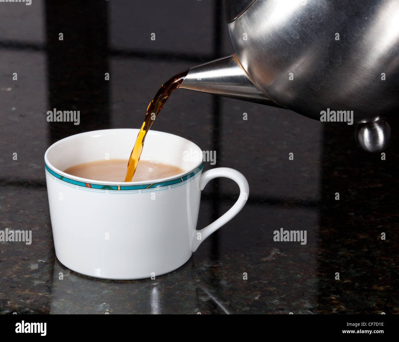 Fresh tea being poured into white cup on marble kitchen worktop Stock ...