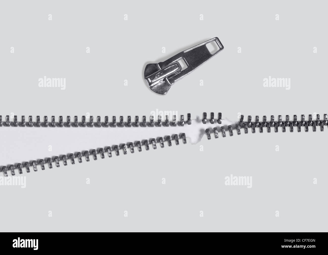 symbolic studio photography of a damaged zipper in light back, seen ...