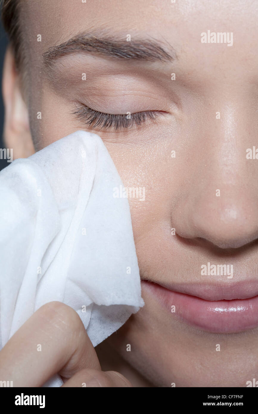 Step by Step Beauty and Make Up Cropped image of female's face, wiping ...