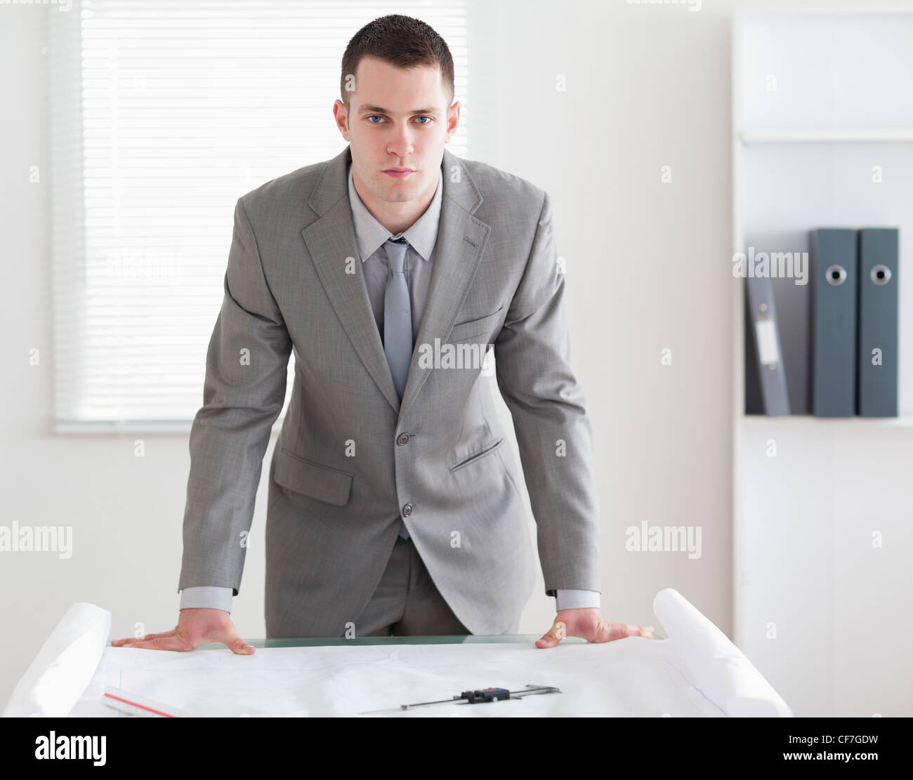 Architect standing behind a table Stock Photo - Alamy