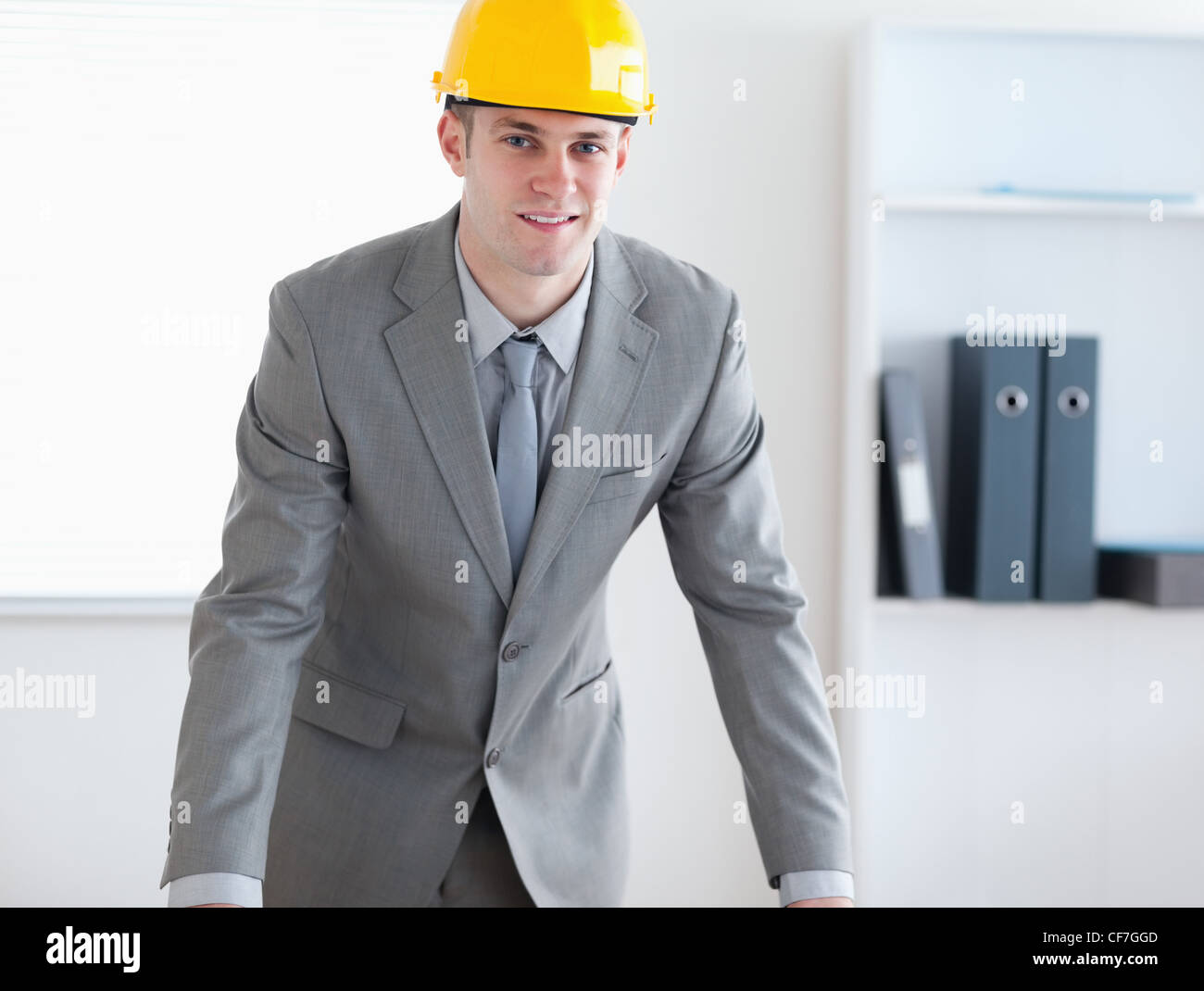 Standing and smiling architect Stock Photo - Alamy