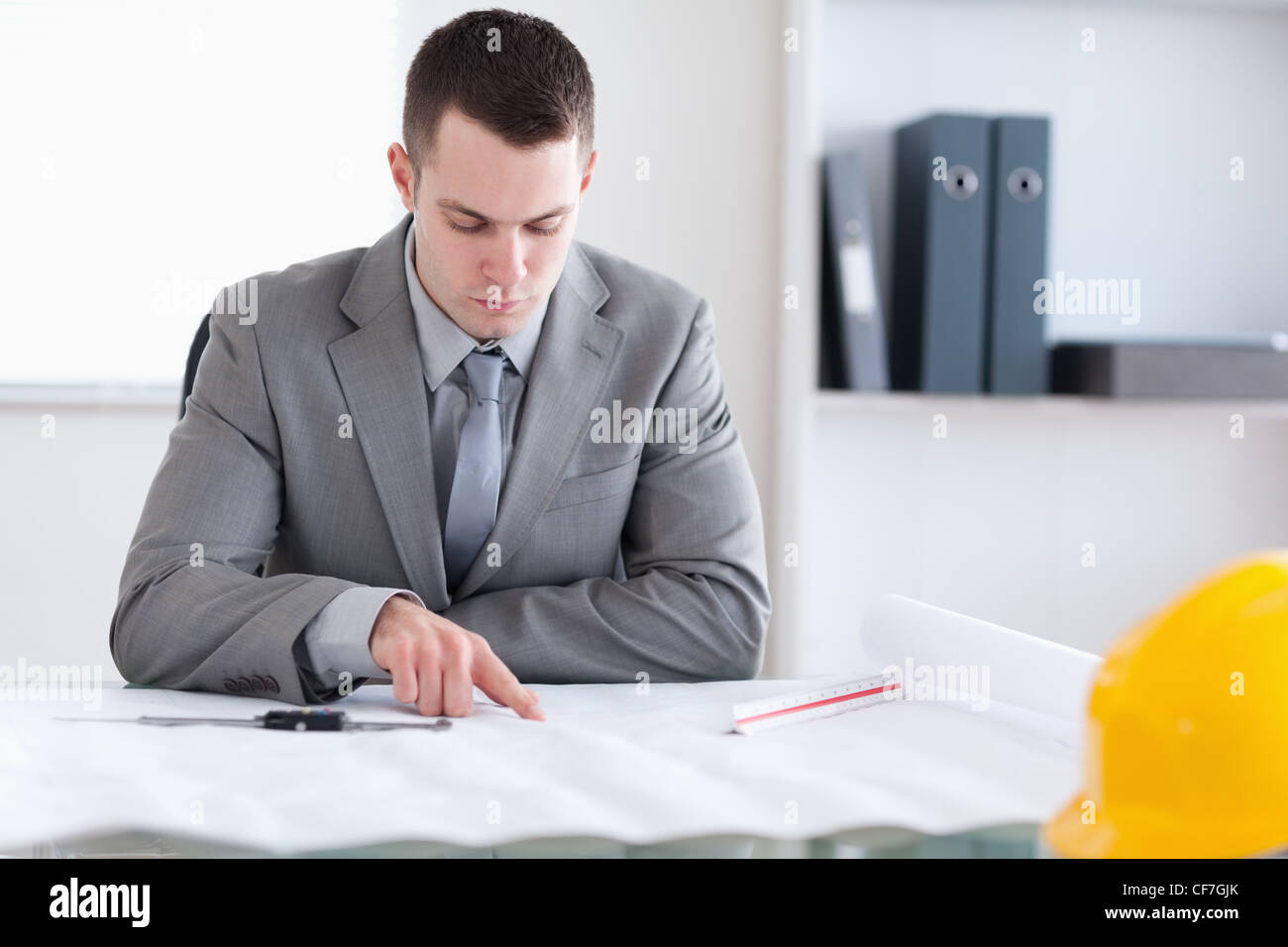 Architect checking building plan Stock Photo - Alamy