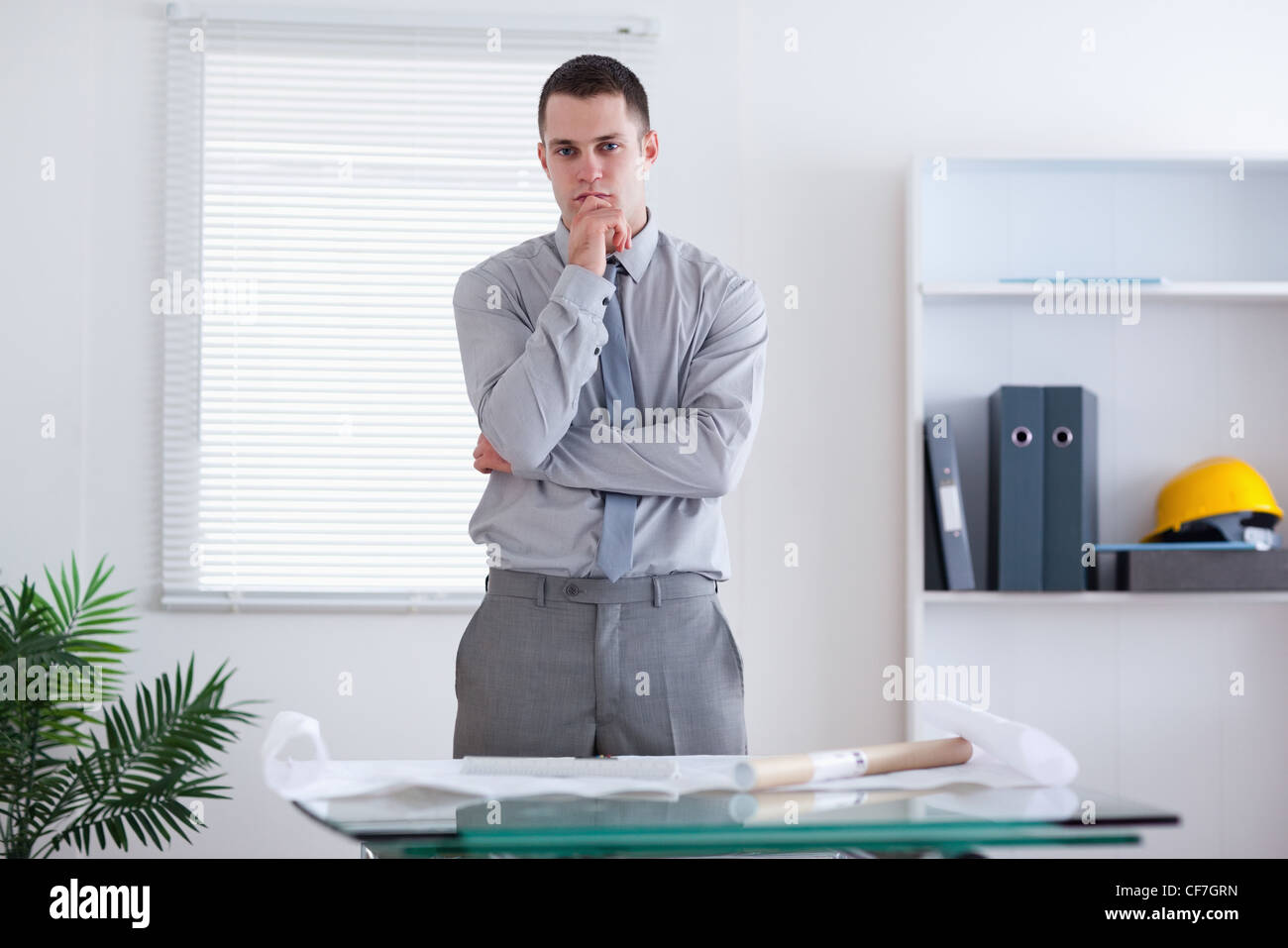 Businessman standing and thinking Stock Photo - Alamy