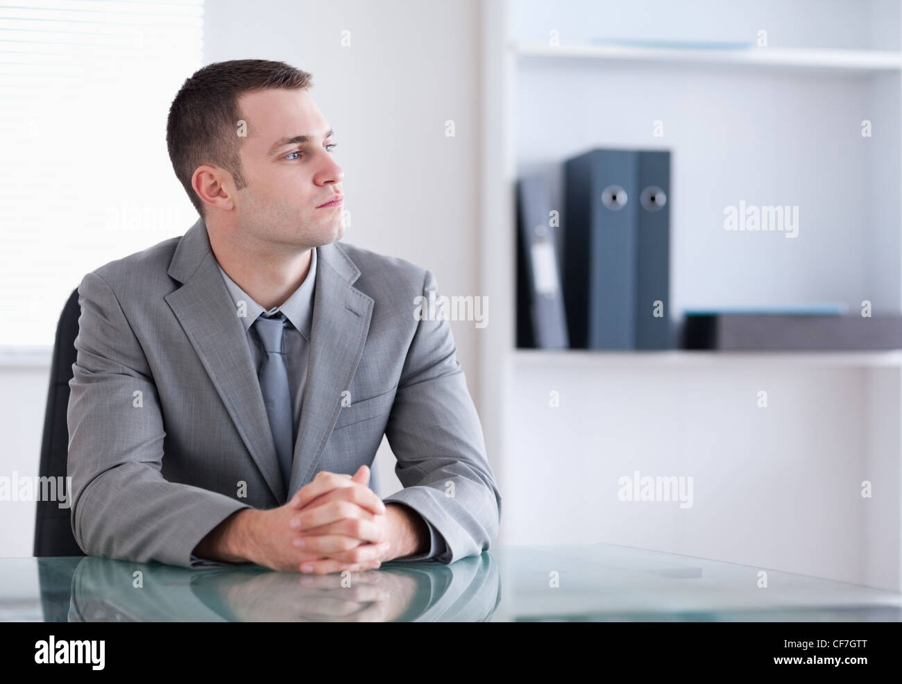 Adult man sitting behind table hi-res stock photography and images - Alamy