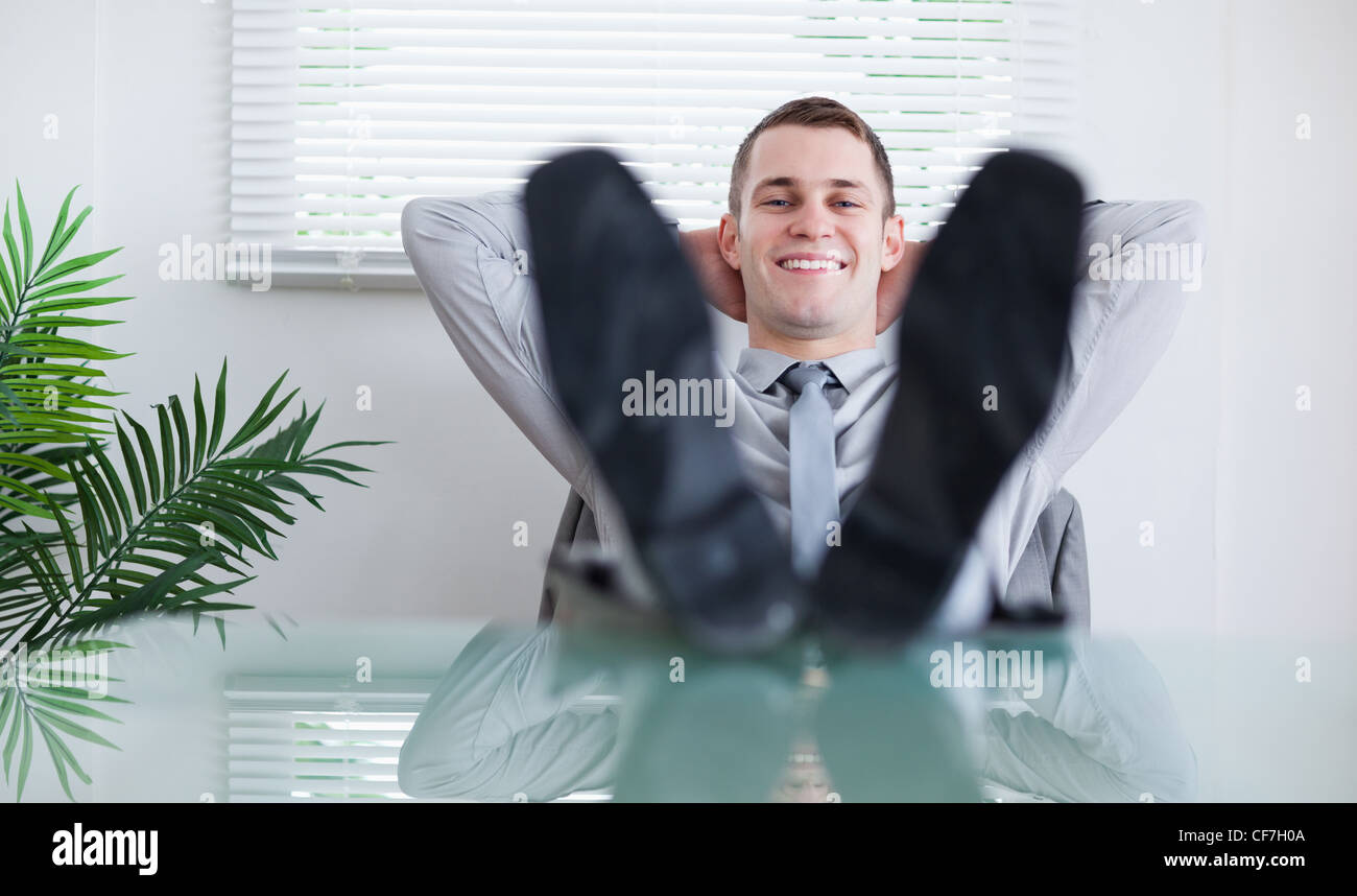 Smiling businessman sitting back Stock Photo - Alamy
