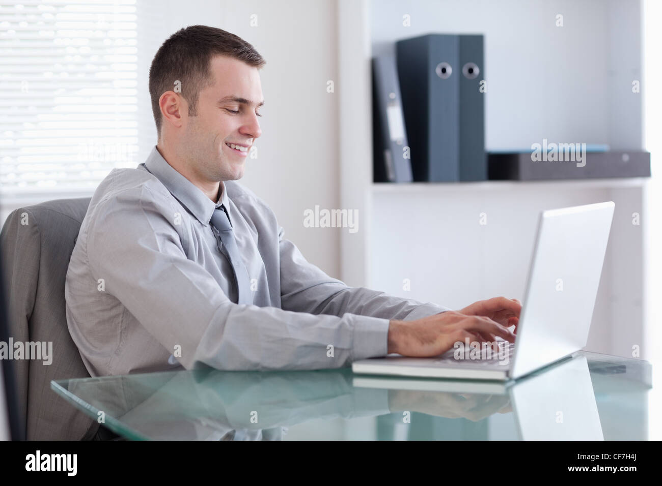 Smiling businessman working on his laptop Stock Photo - Alamy