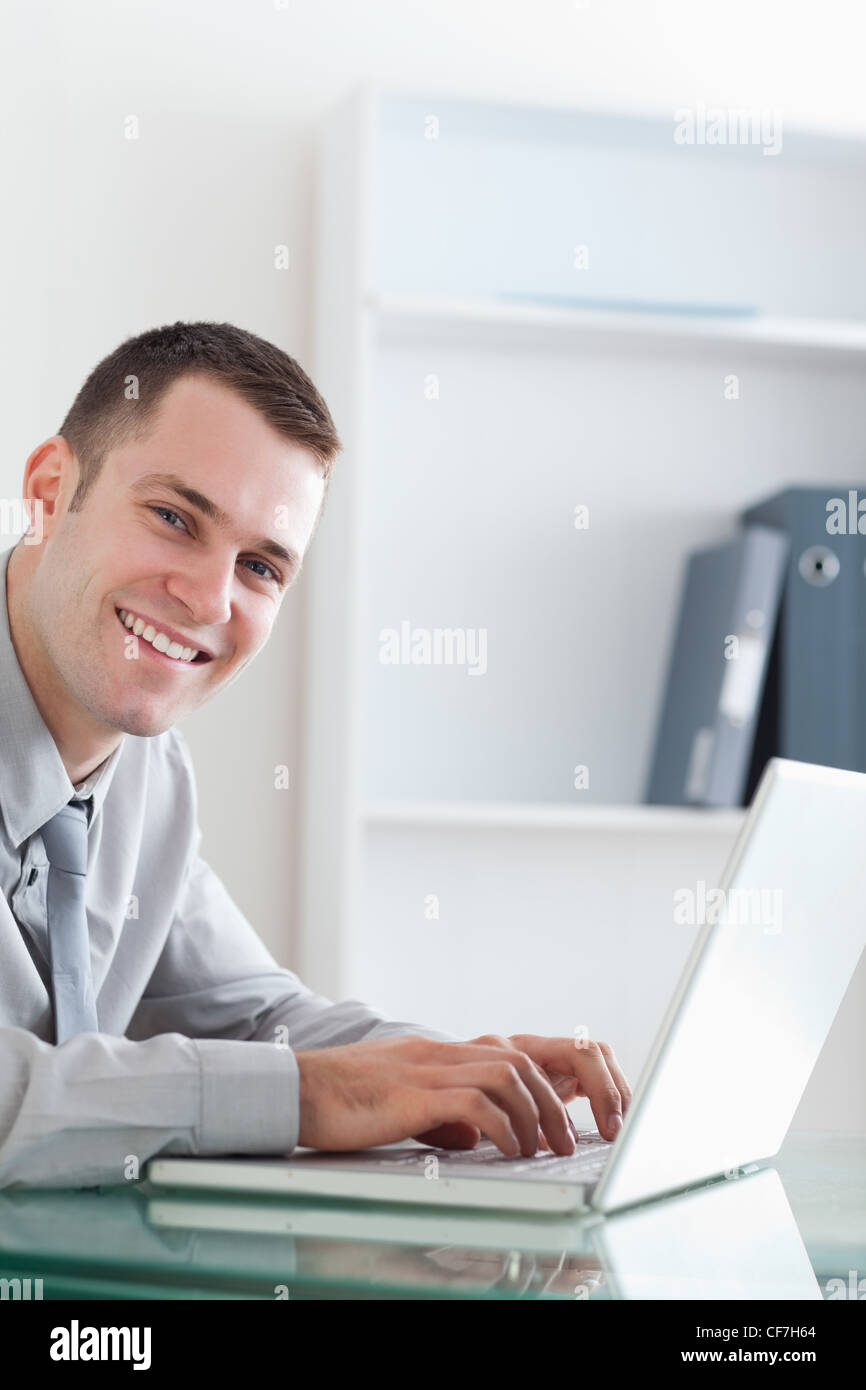 Happy businessman typing on his laptop Stock Photo - Alamy