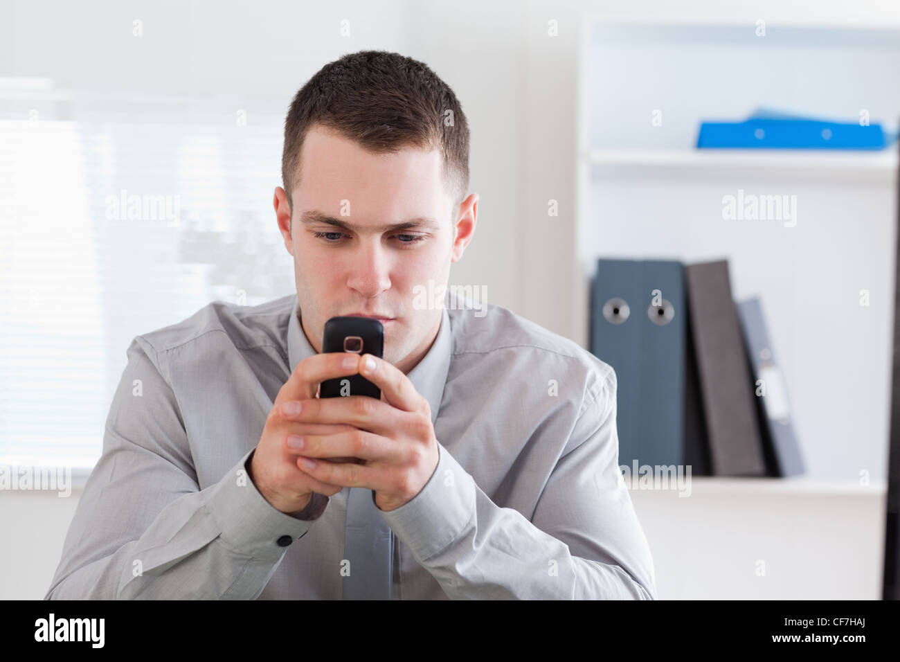 Businessman typing a text message Stock Photo - Alamy