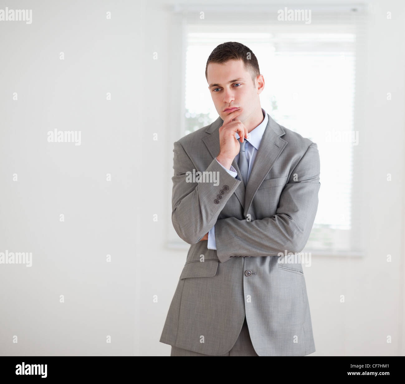 Standing businessman considering Stock Photo - Alamy
