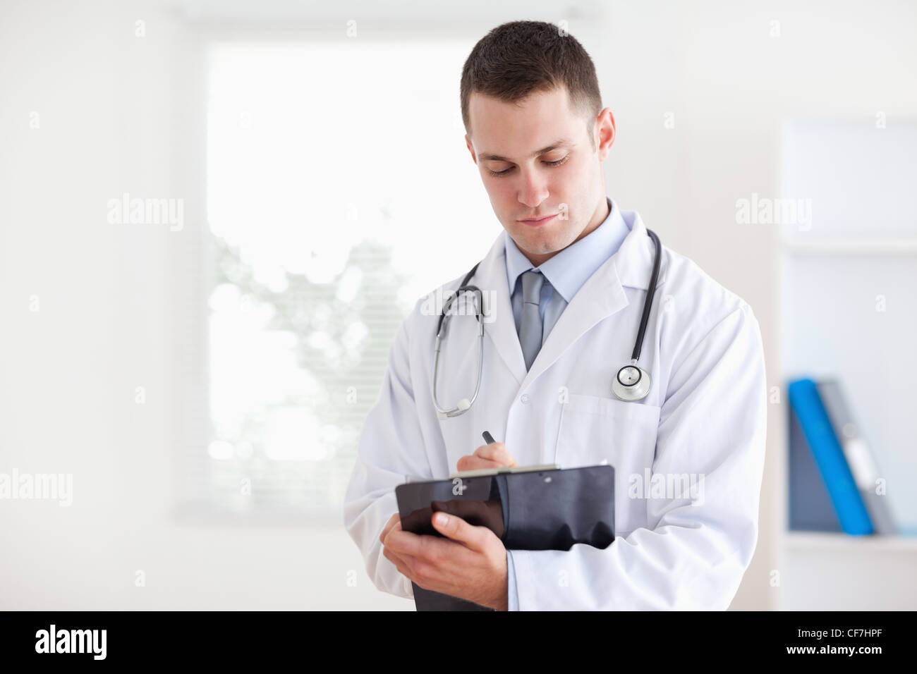 Doctor reading his notes Stock Photo - Alamy