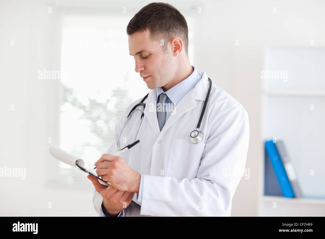 Doctor taking notes carefully Stock Photo - Alamy