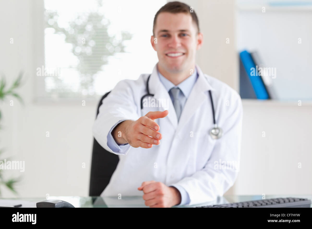 Smiling doctor welcoming patient Stock Photo - Alamy