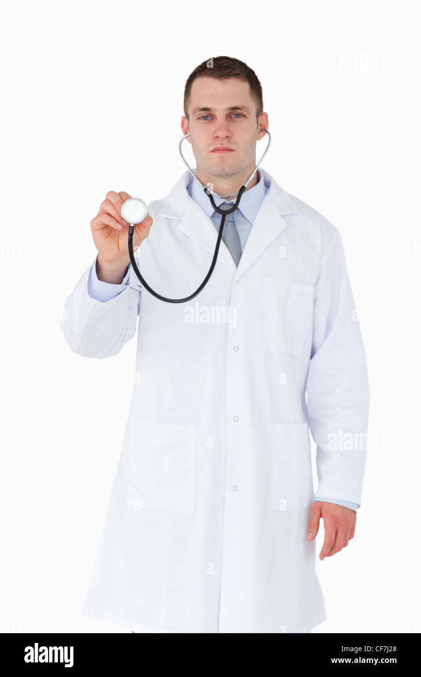Serious looking doctor using stethoscope Stock Photo - Alamy