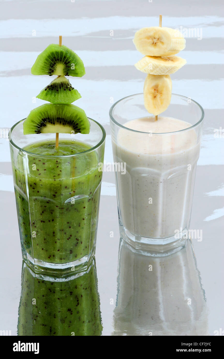 A glass of kiwi smoothie, chunks of kiwi on a skewer in the drink, a ...