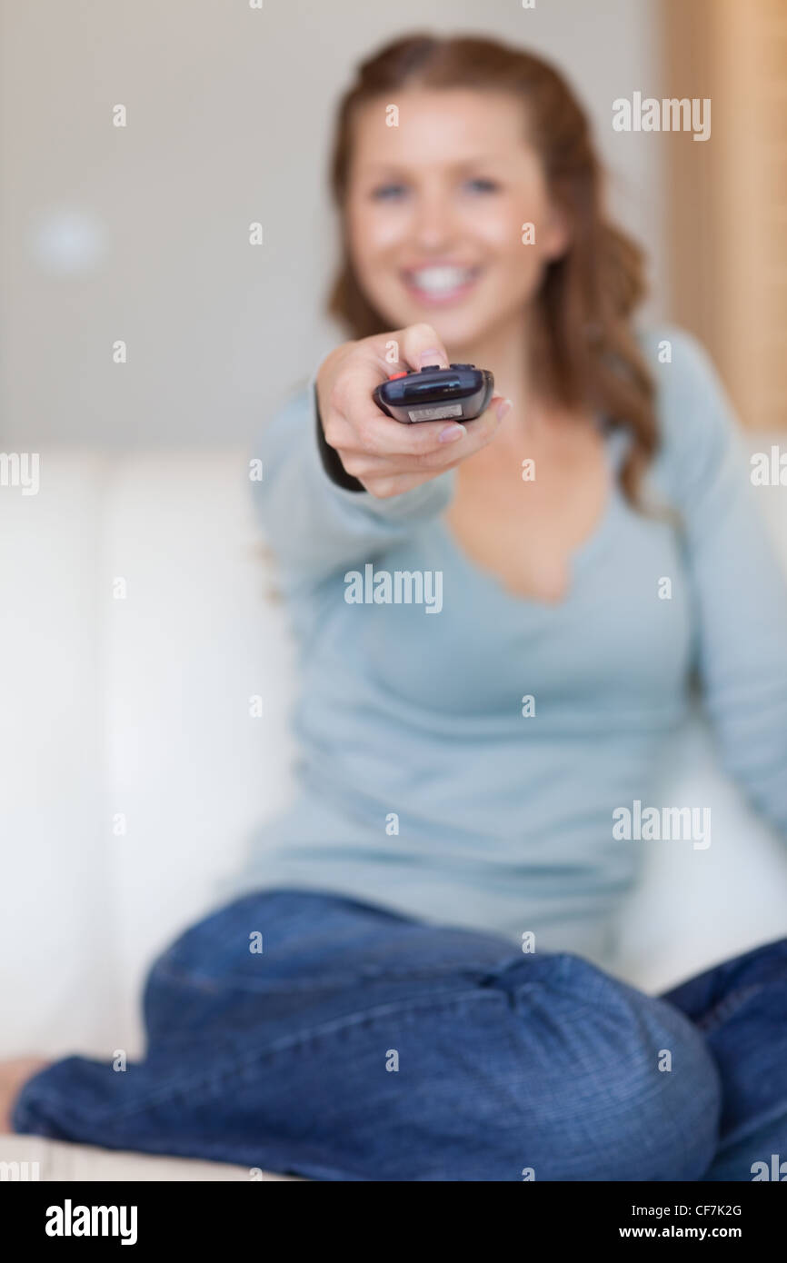 Remote control being used by young woman Stock Photo - Alamy