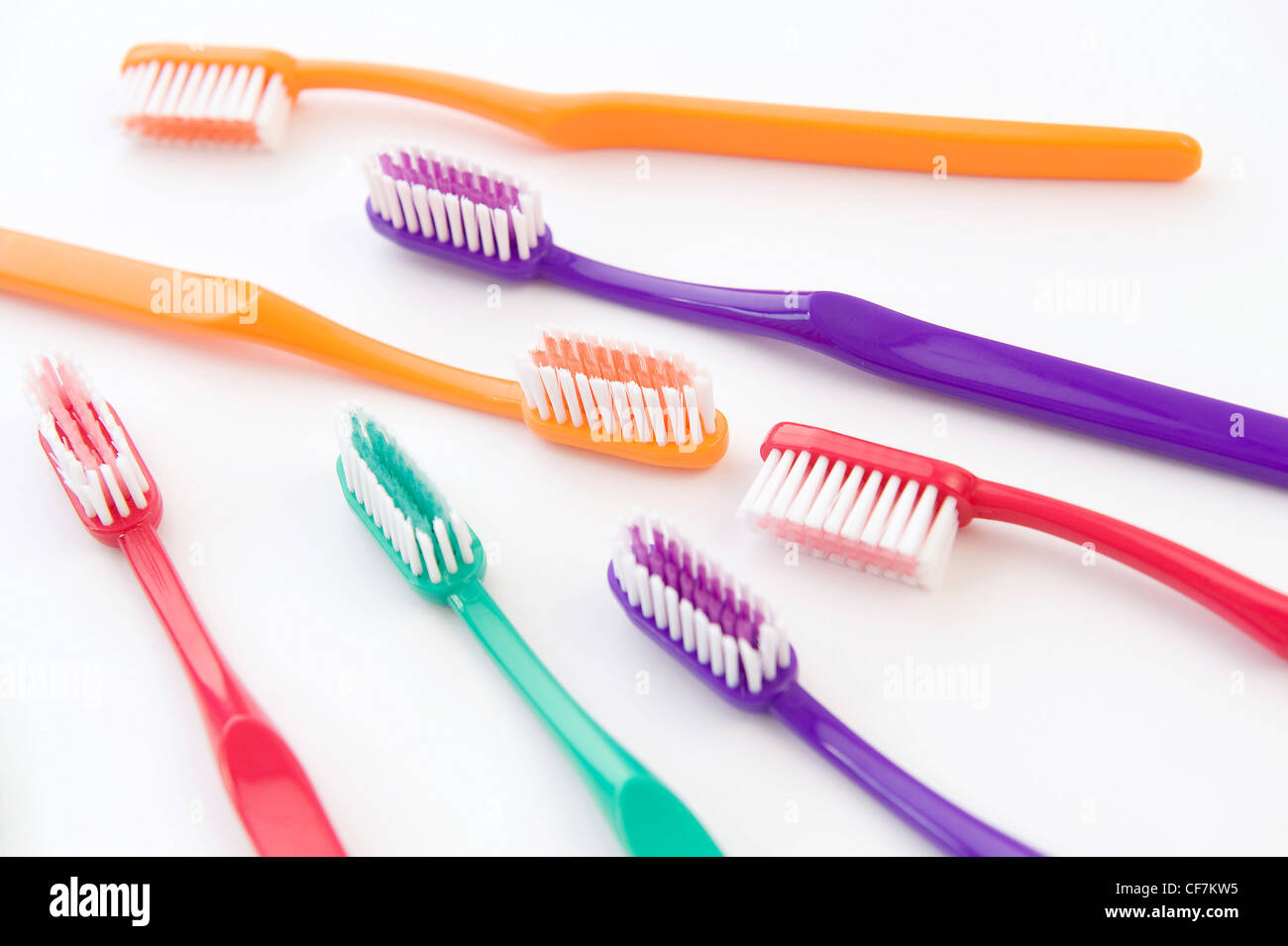 A close up of purple, yellow, green and red toothbrushes at different ...