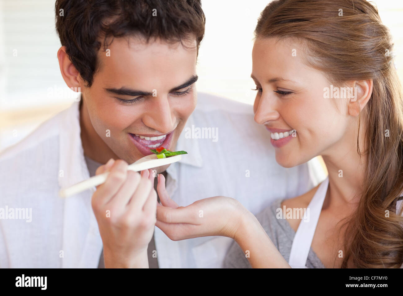 Man is tasting the meal his girlfriend is cooking Stock Photo - Alamy