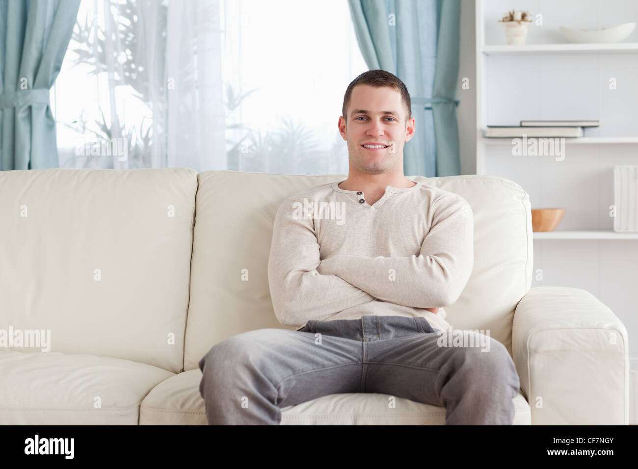 Man sitting on a couch Stock Photo - Alamy