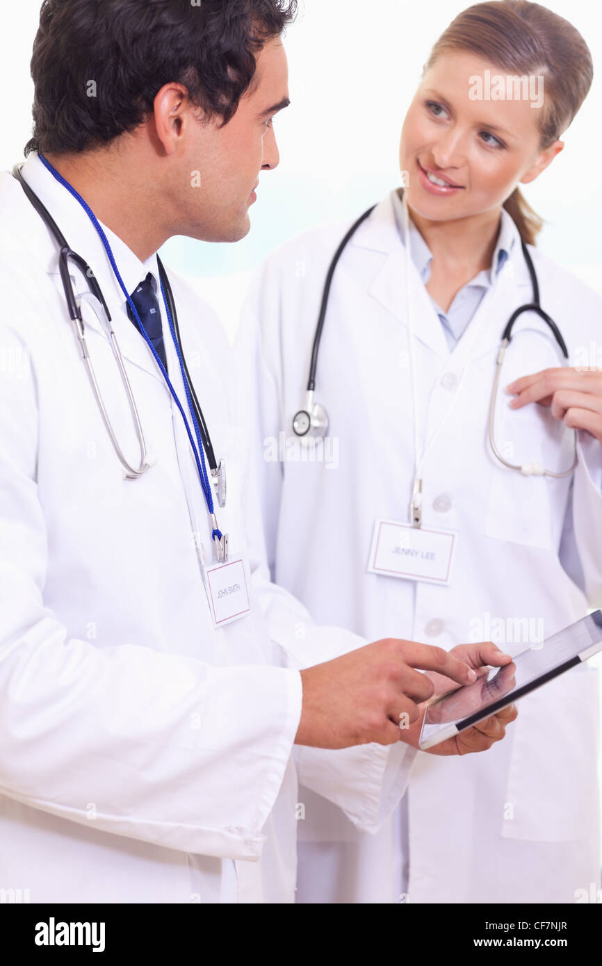 Assistant doctors talking about what's on the tablet Stock Photo - Alamy