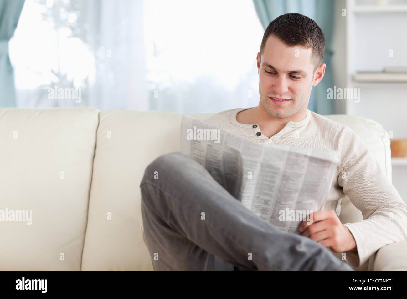 Young man reading a newspaper Stock Photo - Alamy