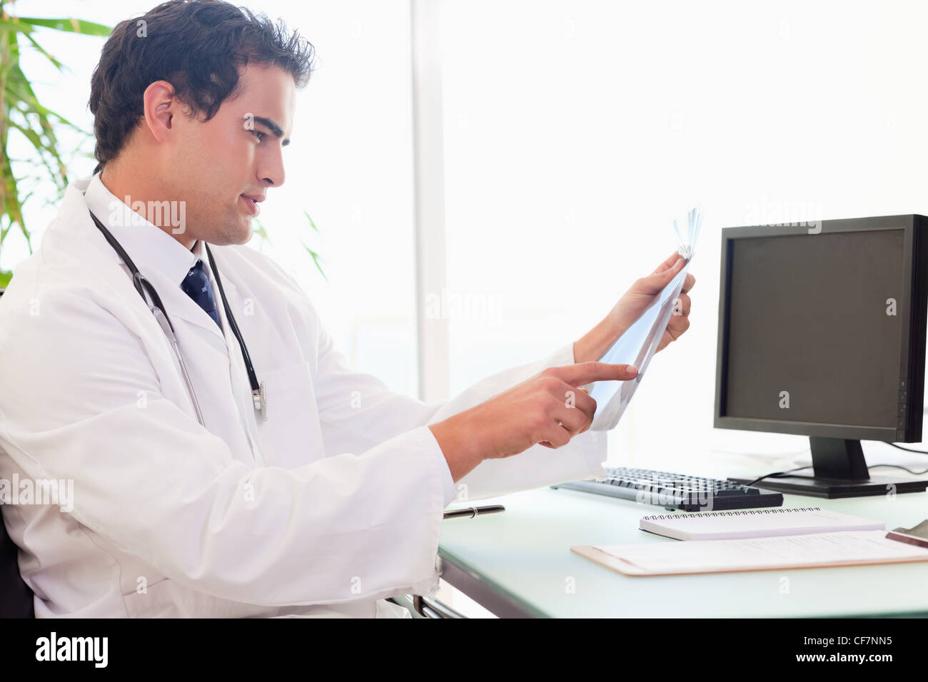Side view of doctor with an x-ray at his desk Stock Photo - Alamy