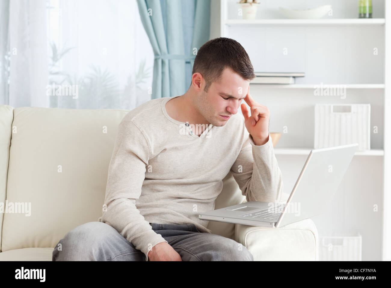 Man having a headache while using a laptop Stock Photo - Alamy