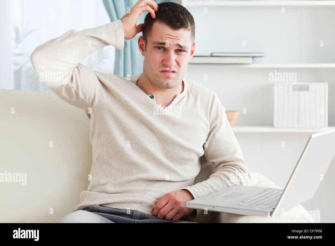 Confused man using a laptop Stock Photo - Alamy