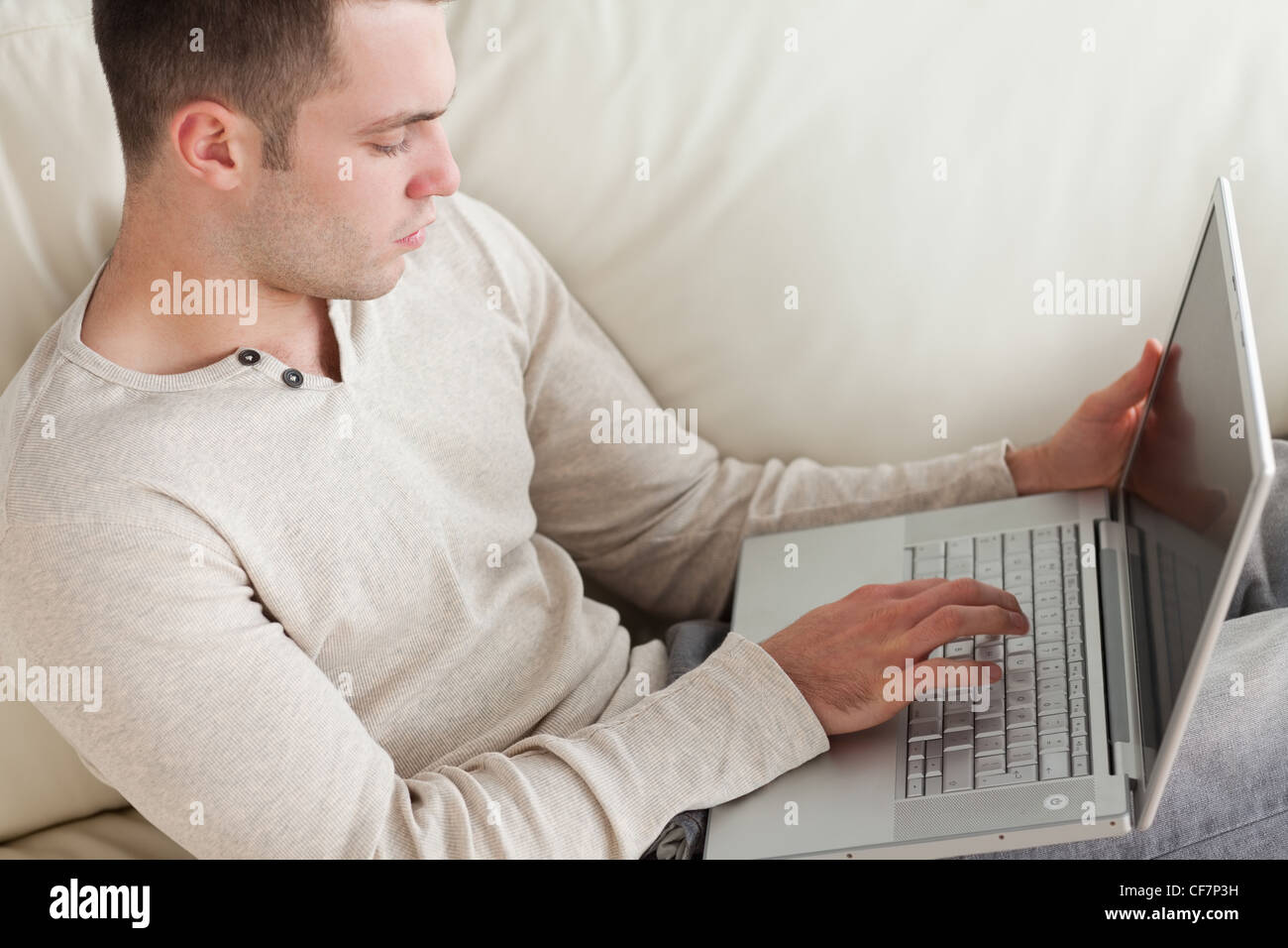 Good looking man relaxing with a laptop Stock Photo - Alamy