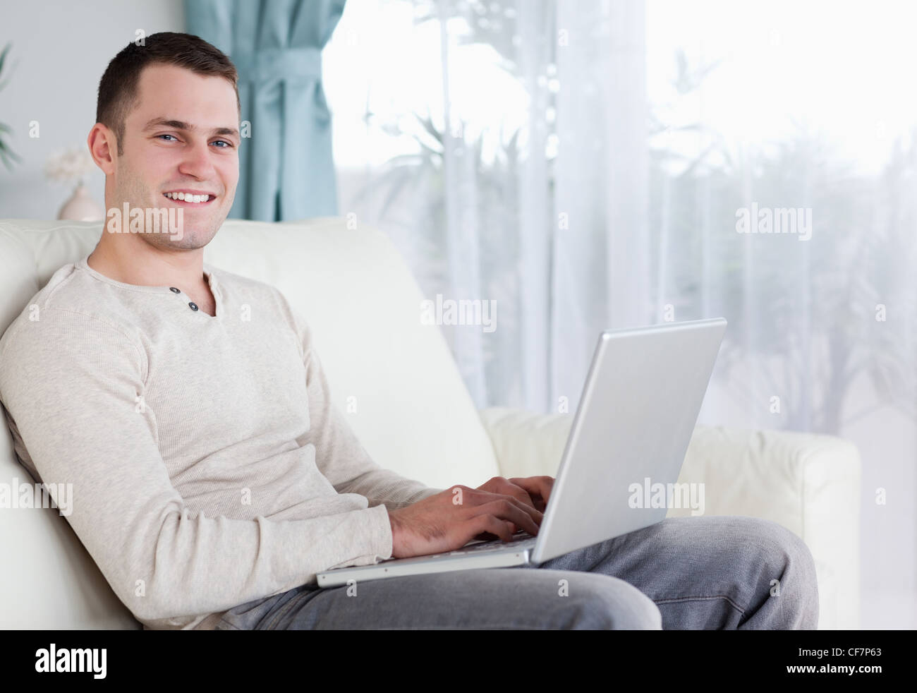 Happy man typing on his notebook Stock Photo - Alamy