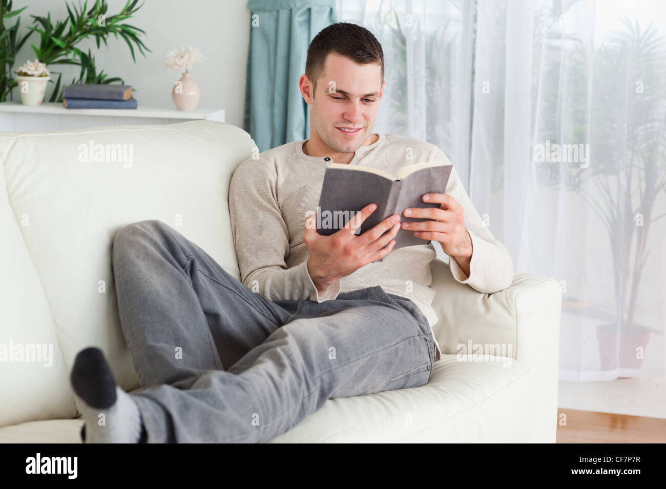 Smiling man reading a book Stock Photo - Alamy