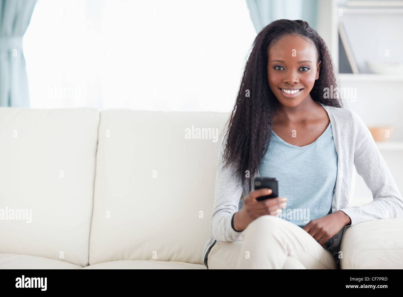 Woman typing text message on the sofa Stock Photo - Alamy
