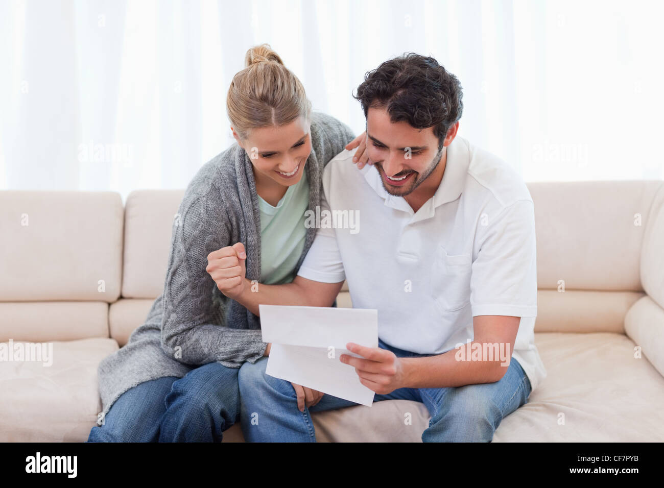 Cheerful couple reading a letter Stock Photo - Alamy