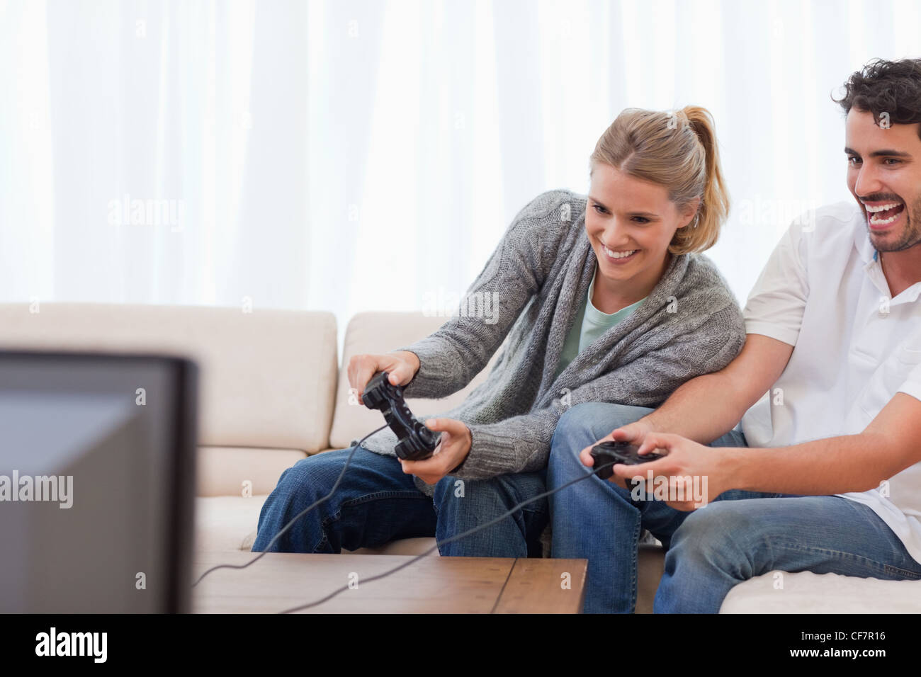 Laughing couple playing video games Stock Photo - Alamy