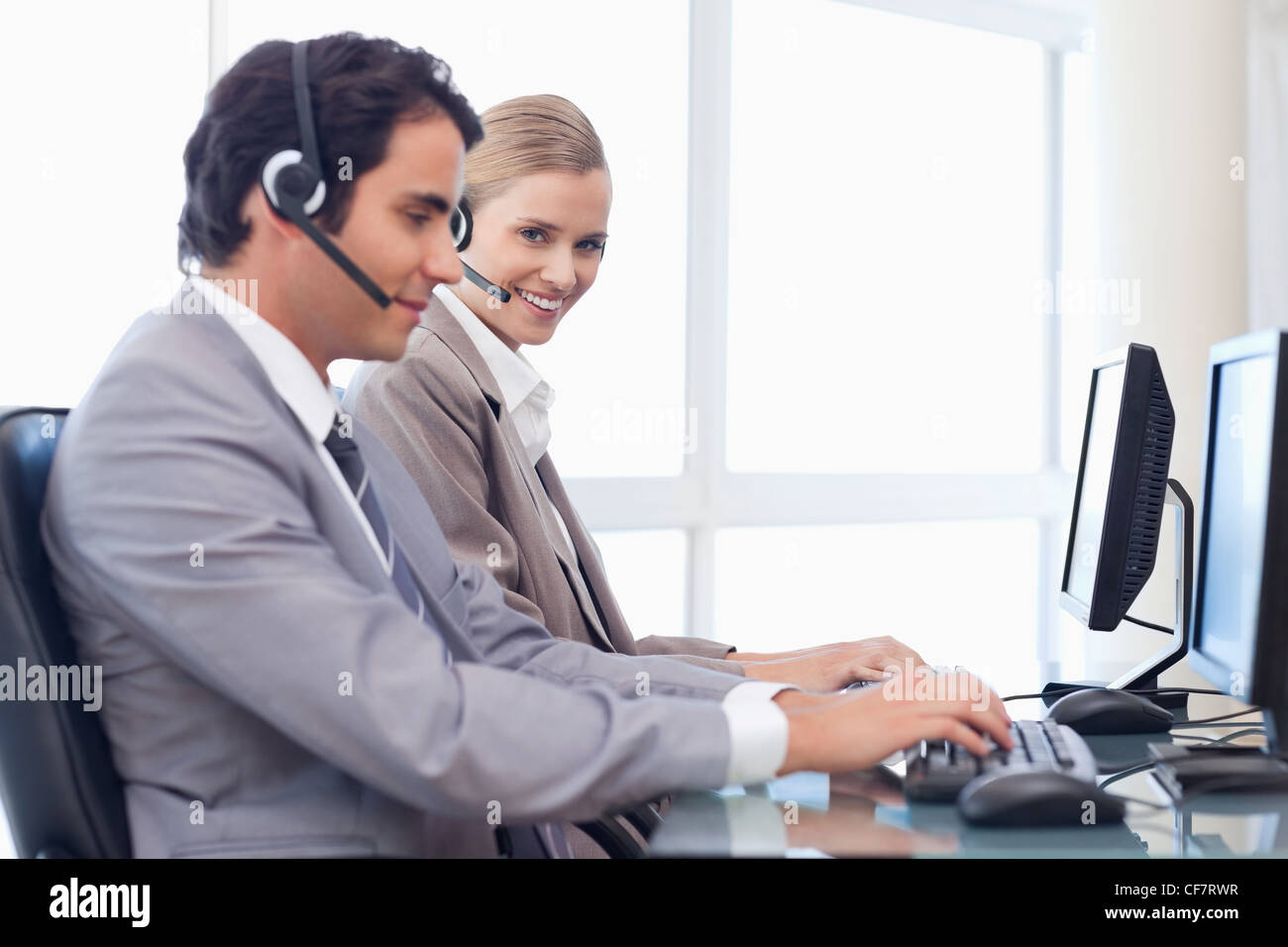 Happy operators using a computer Stock Photo - Alamy