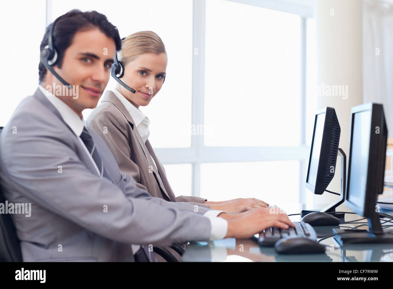 Good looking operators using a computer Stock Photo - Alamy
