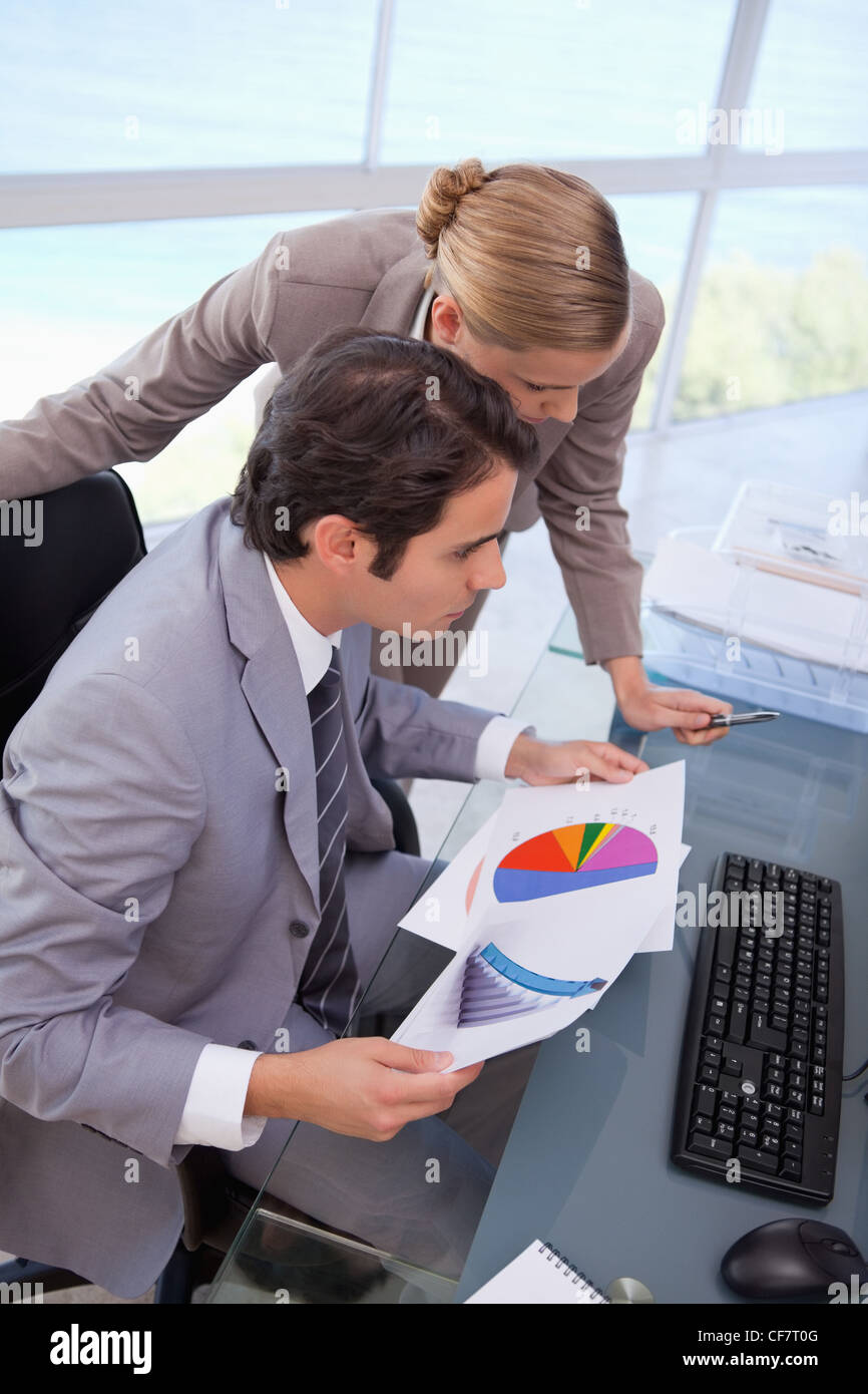 Portrait of a business team looking at a graph Stock Photo - Alamy