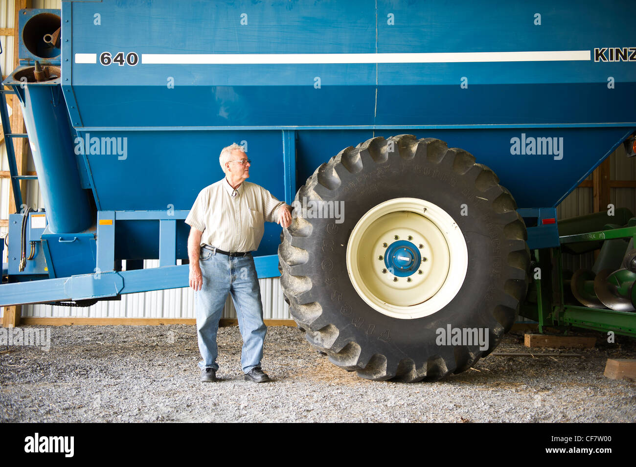 Farmer standing next to machinery for grain production Stock Photo - Alamy