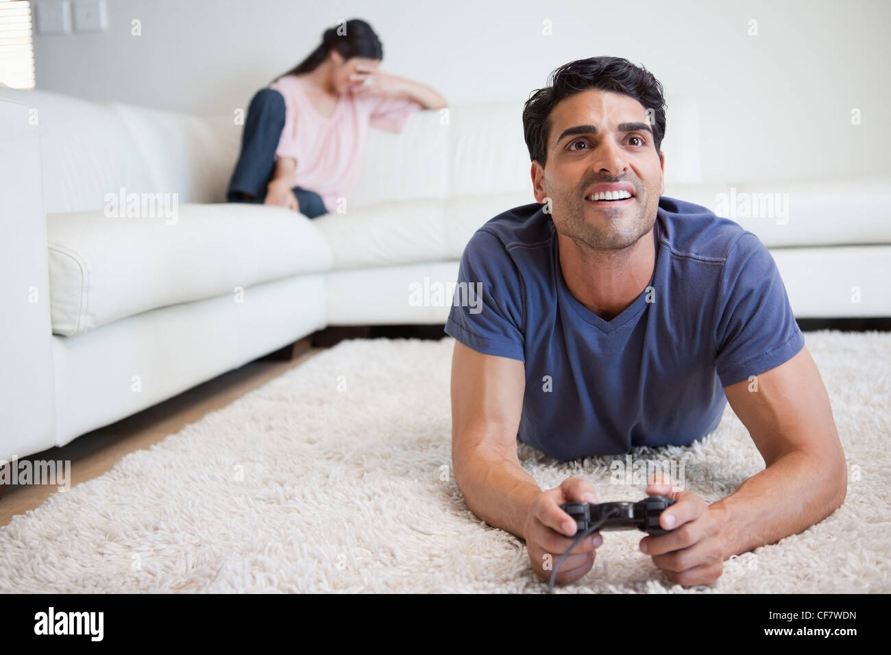Man playing video games while his fiance is crying Stock Photo - Alamy
