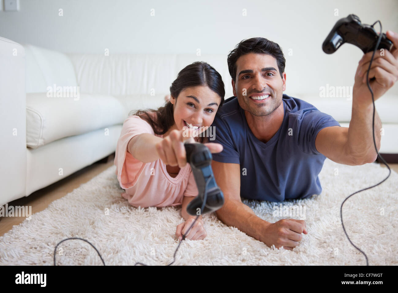 Playful young couple playing video games Stock Photo - Alamy