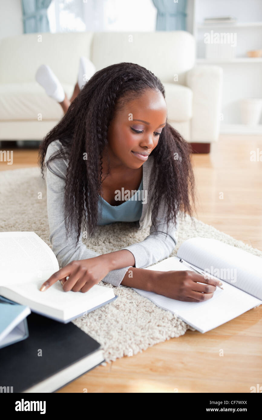 Woman lying on carpet doing her homework Stock Photo - Alamy