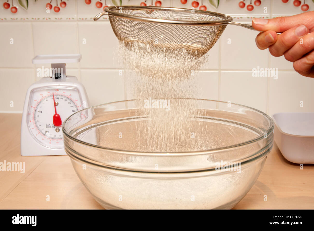 Making a cake pouring flour through a sieve into a bowl Stock Photo - Alamy